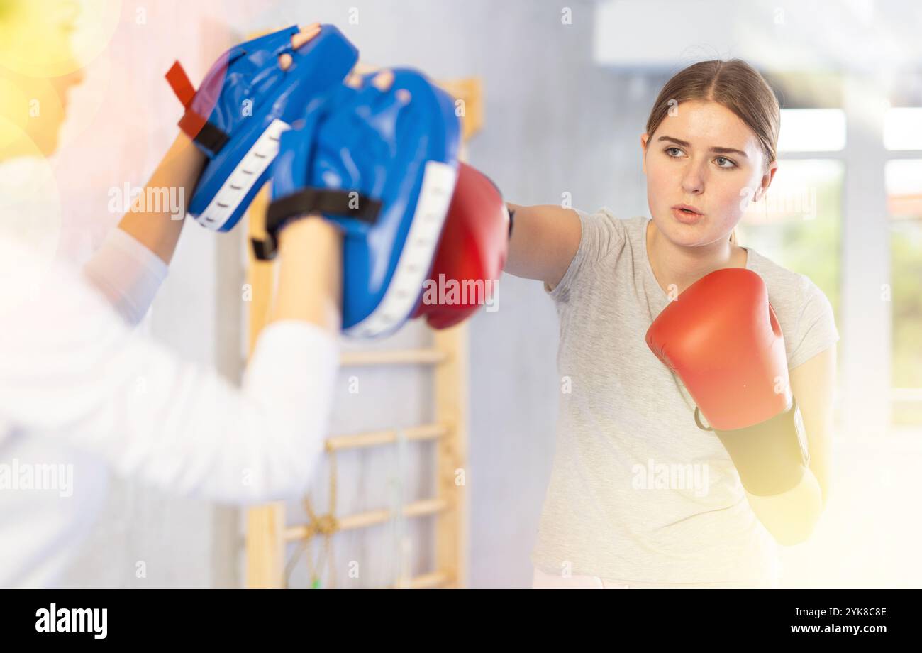 Boxing training - teen girl wearing boxing gloves exercise and punch to ...
