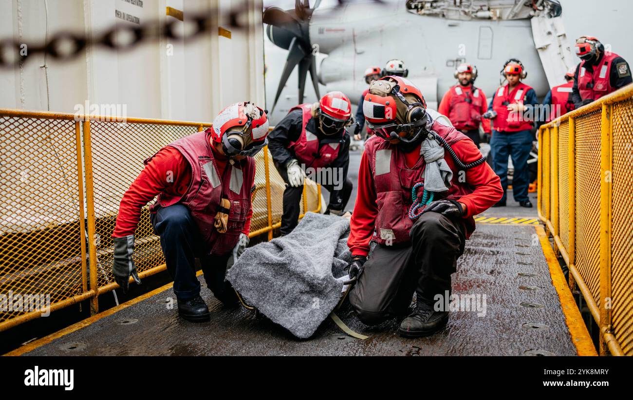 Sailors lower a medical patient onto a weapons elevator on the flight ...