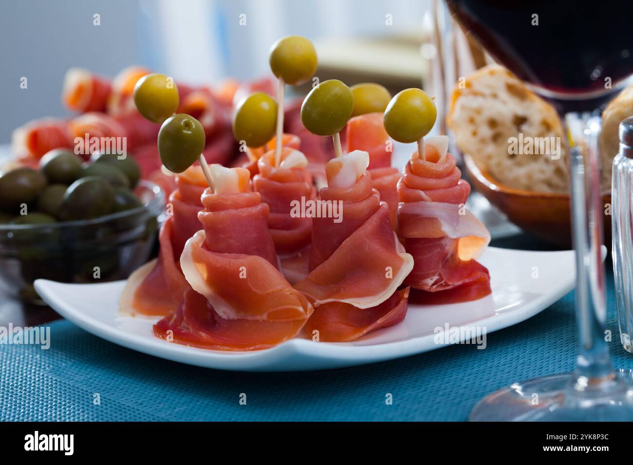 Traditional Spanish tapas - rolls of jamon serrano served with green ...