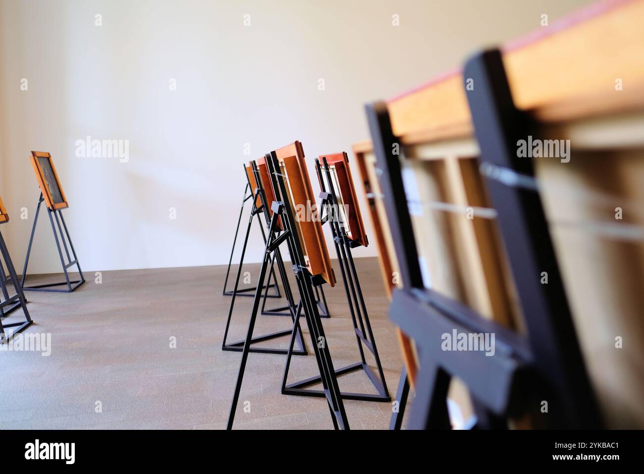 Side view of wooden easels at a museum art exhibit seen from behind ...