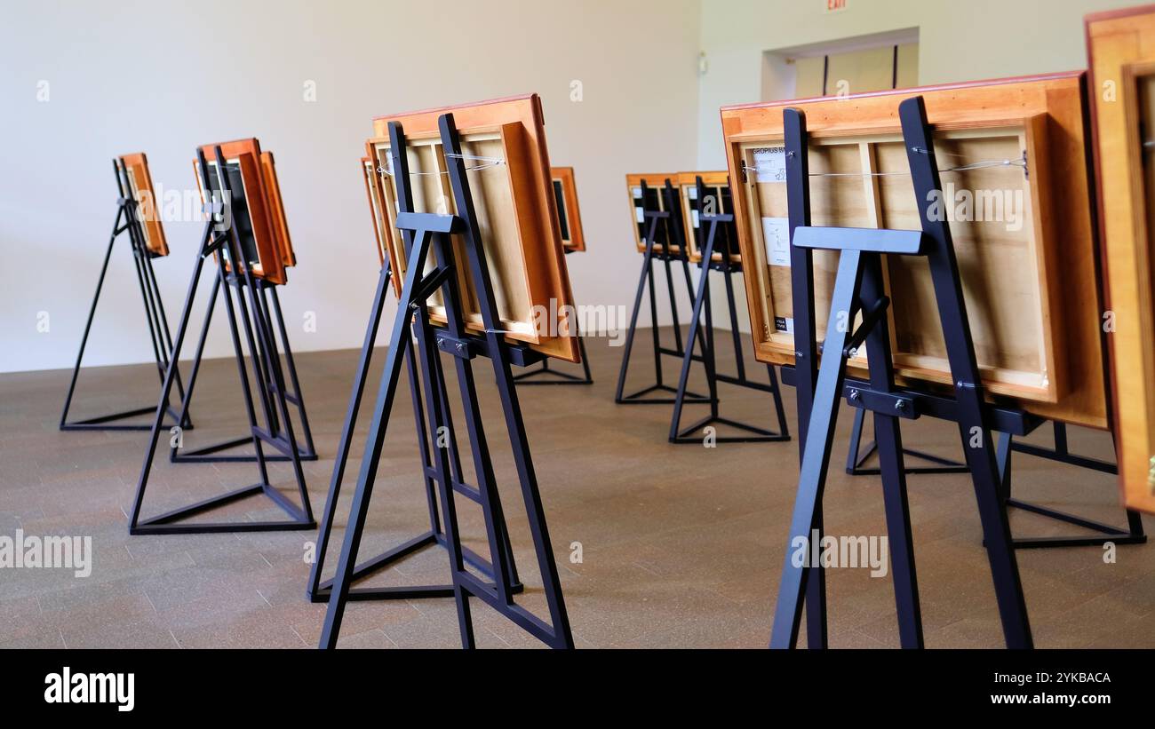 Side view of wooden easels at a museum art exhibit seen from behind ...