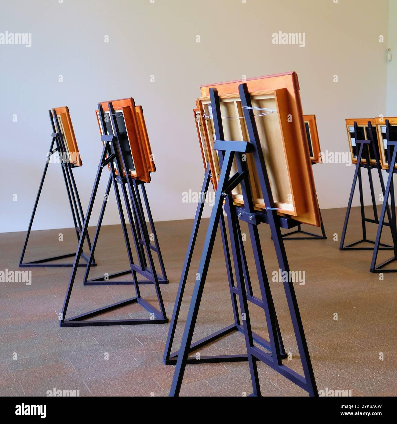 Side view of wooden easels at a museum art exhibit seen from behind ...