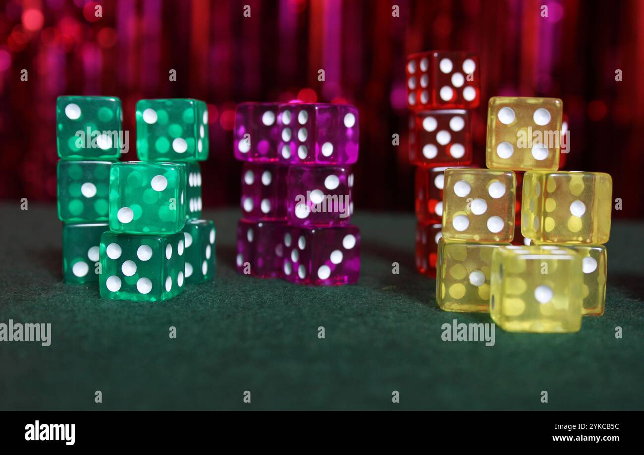 Stacks of Colorful Dice on Green Felt With Pink Bokeh Background Stock ...