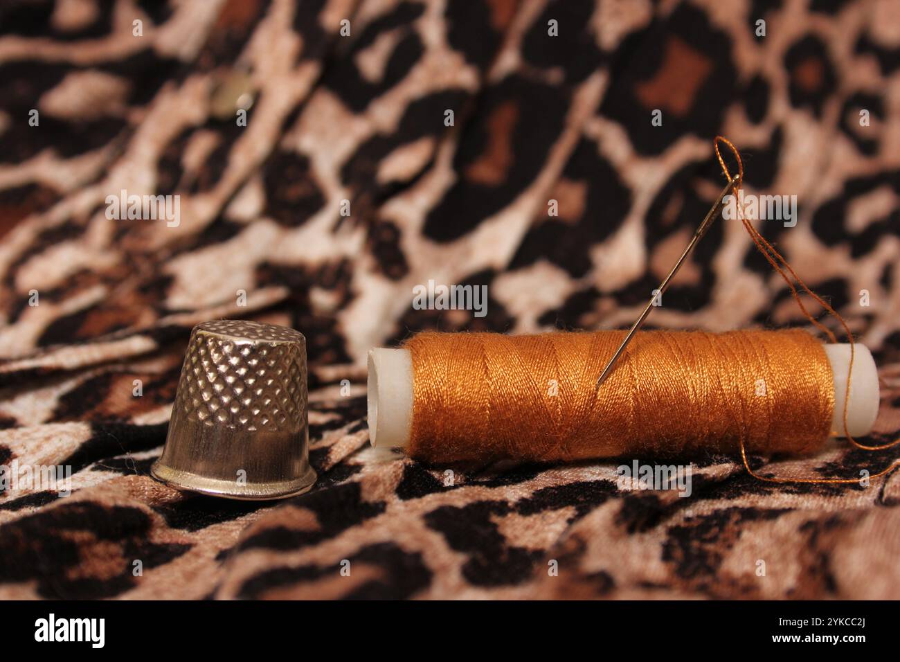 Spool of Tan Thread on Vintage Leopard Print Fabric Stock Photo - Alamy