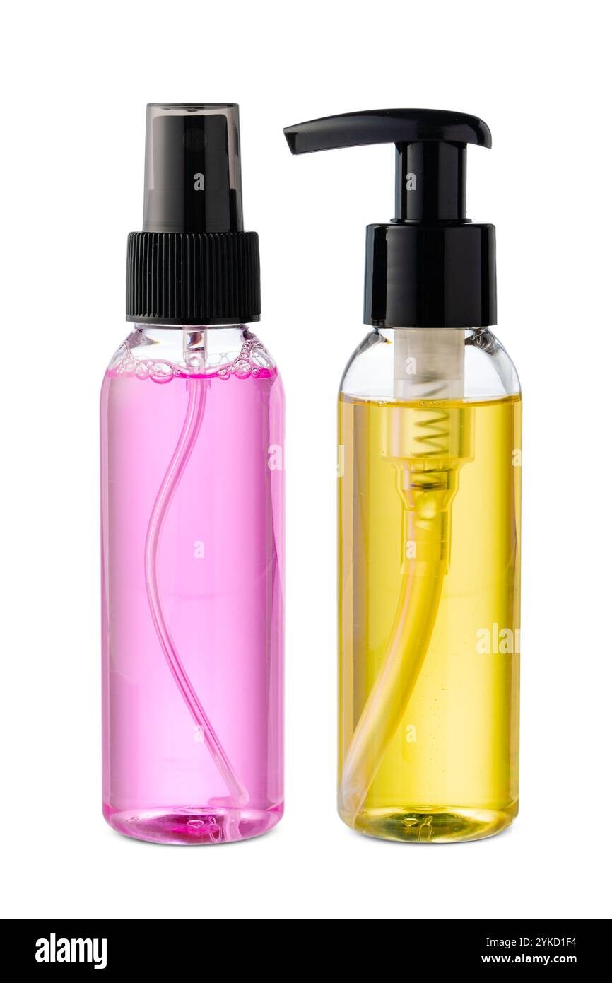 Various bottles with colored liquids and pumps arranged on white ...