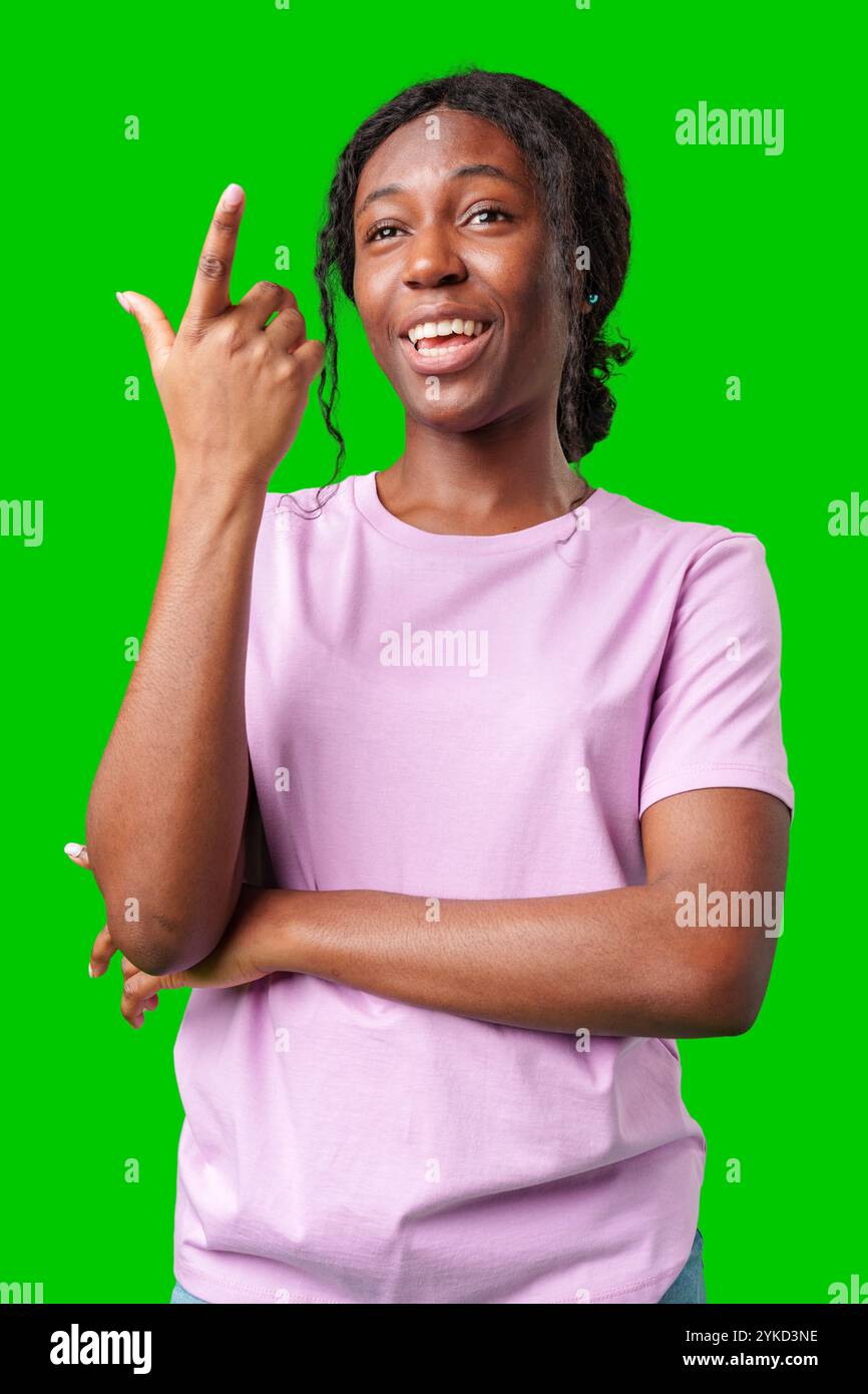 Thoughtful woman pondering in front of a bright green background during ...