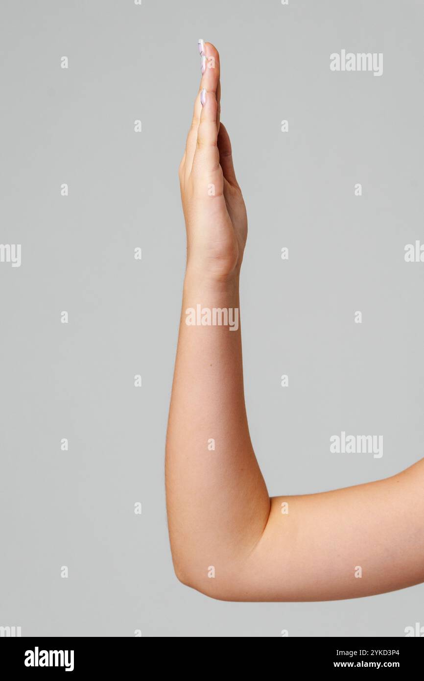 Raised hand against a neutral background in a softly lit setting Stock ...