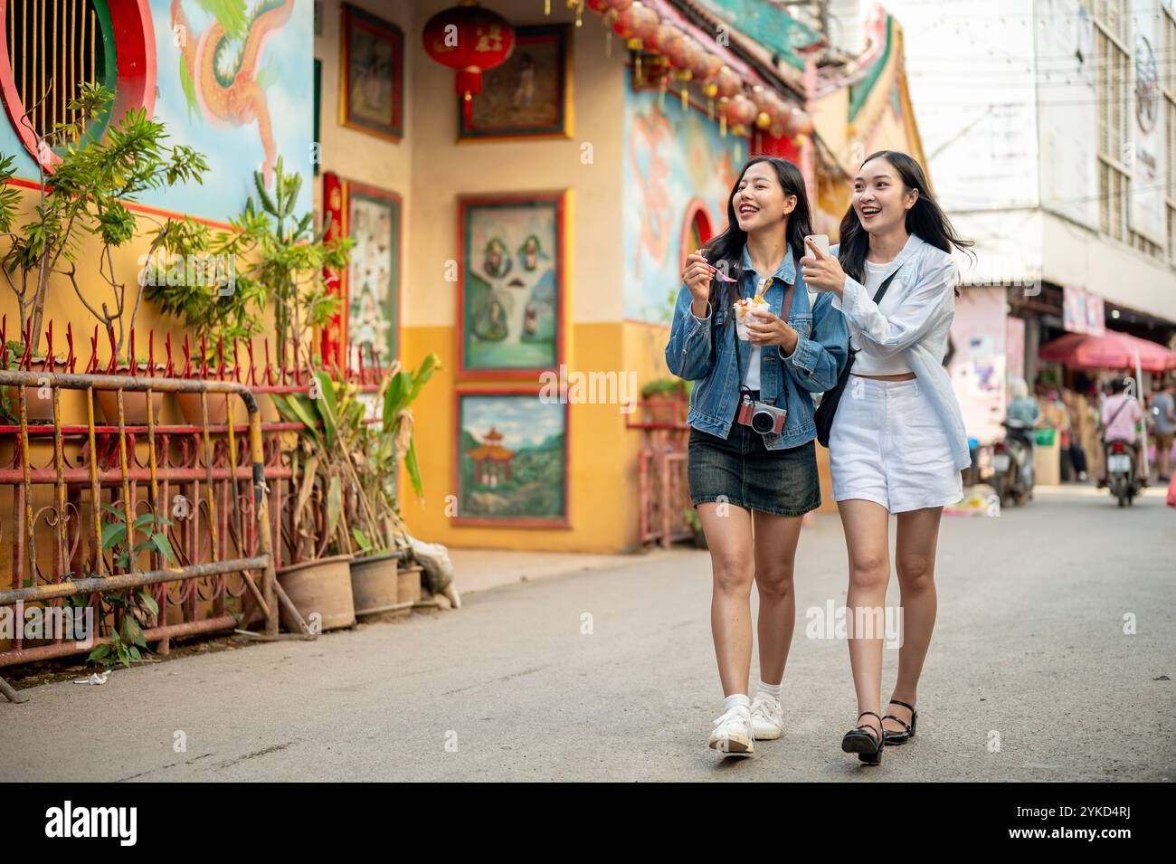 Two beautiful, joyful Asian female friends explore the city in Chiang ...