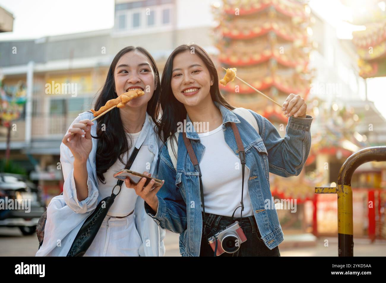 A portrait of two beautiful, joyful young Asian female tourists are ...