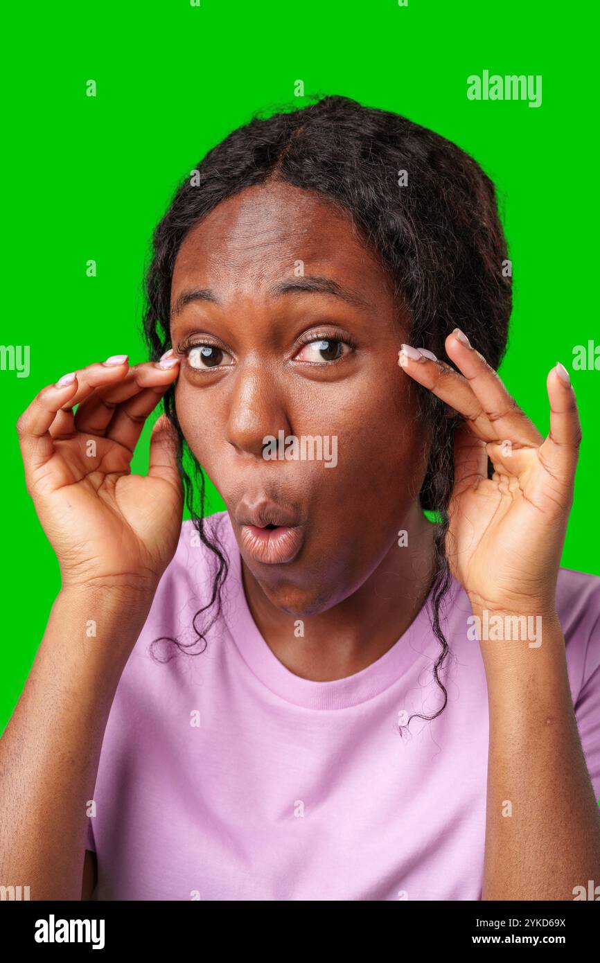 Surprised woman expressing shock while posing with hands on her face ...