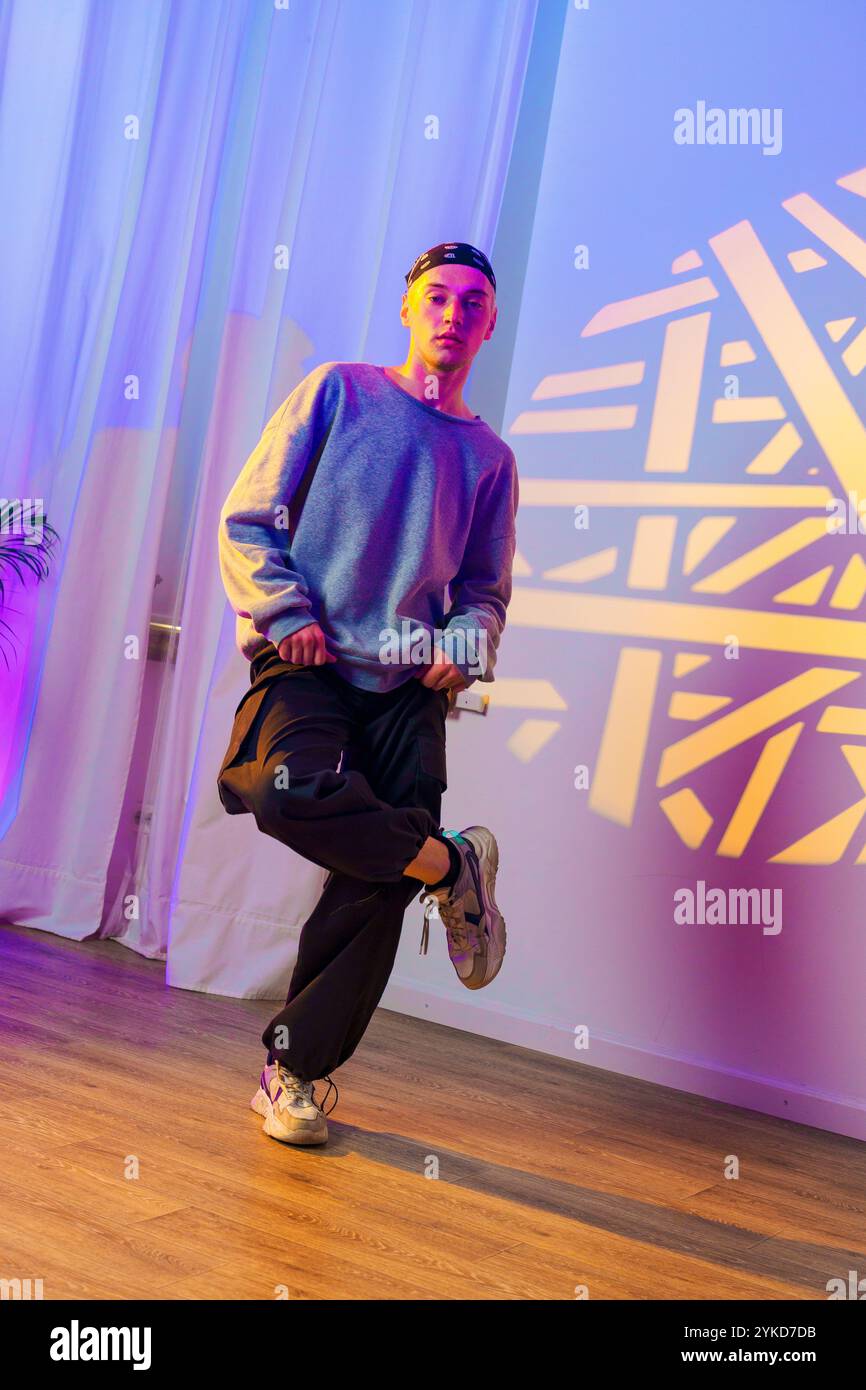 A young man in a blue sweater poses for a photo during a dance class in ...