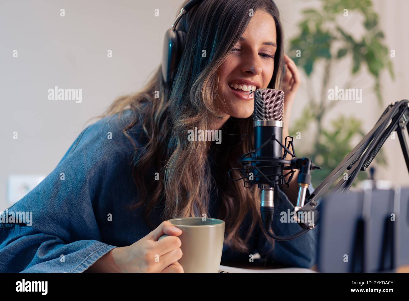 Creative female podcaster taking relaxing coffee break while recording ...