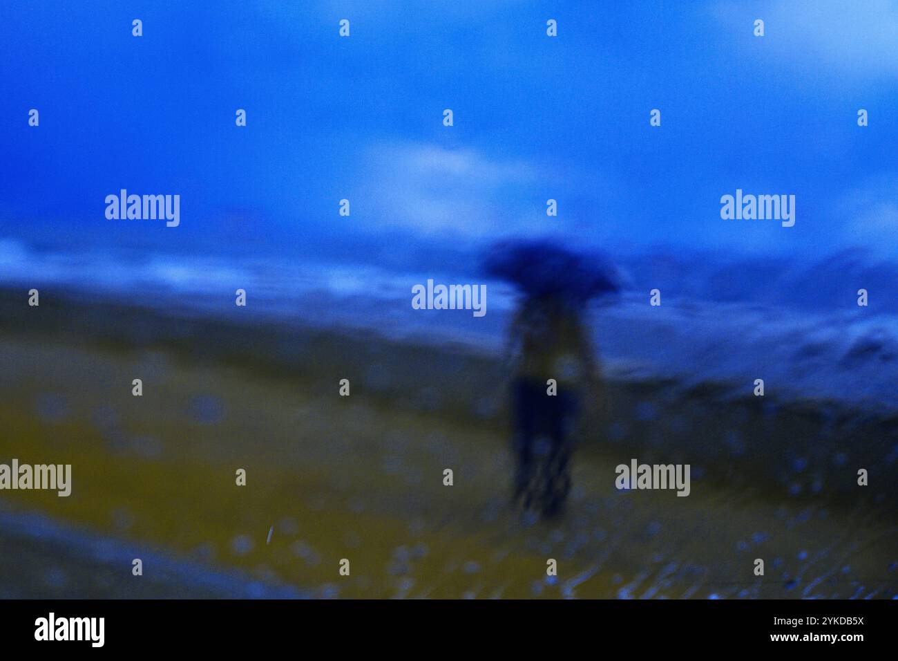 Solitary Figure with Umbrella Distorted by Raindrops on a Rainy day ...