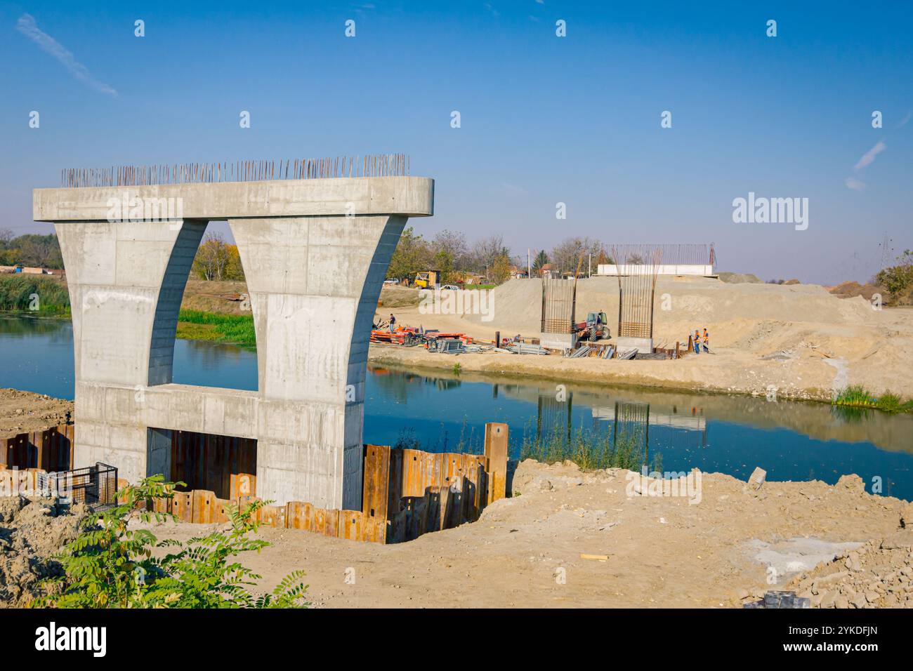 Large modern gray concrete bridge pillar in foundation surrounded by ...
