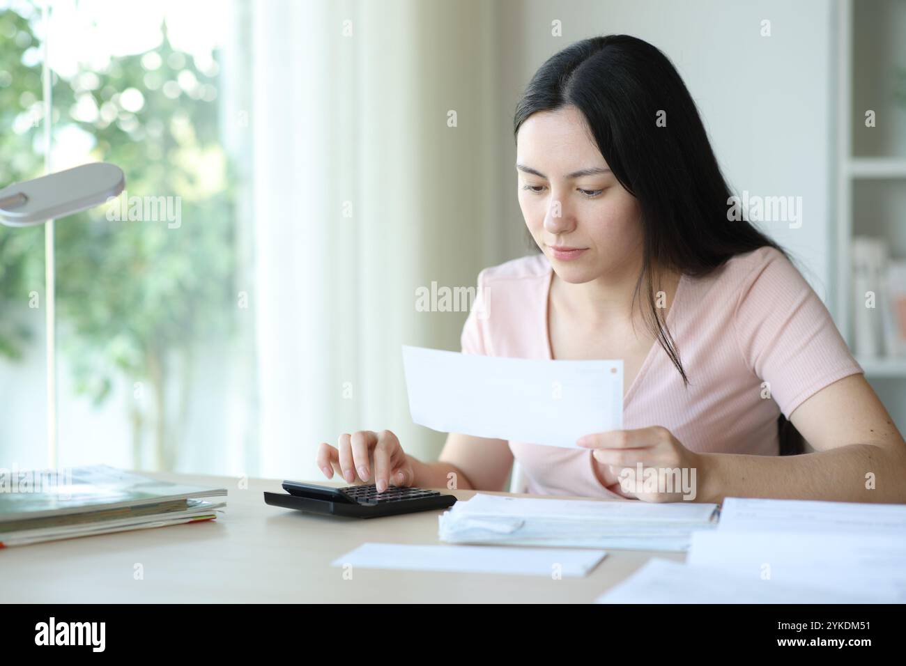 Serious asian woman calculating expenses checking bill at home Stock ...