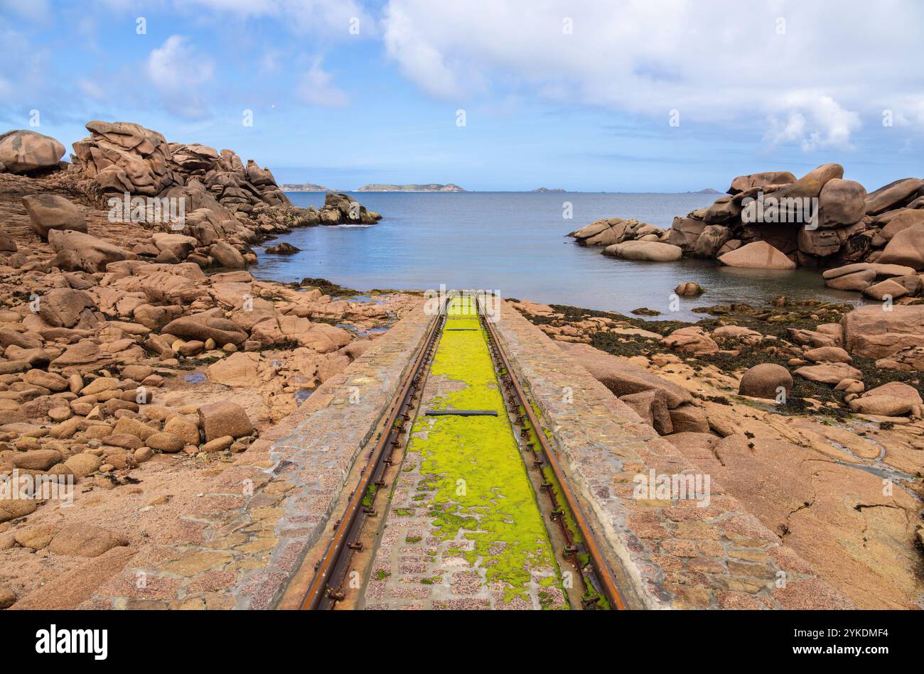 A scenic coastal landscape featuring rocky formations of pink granite ...