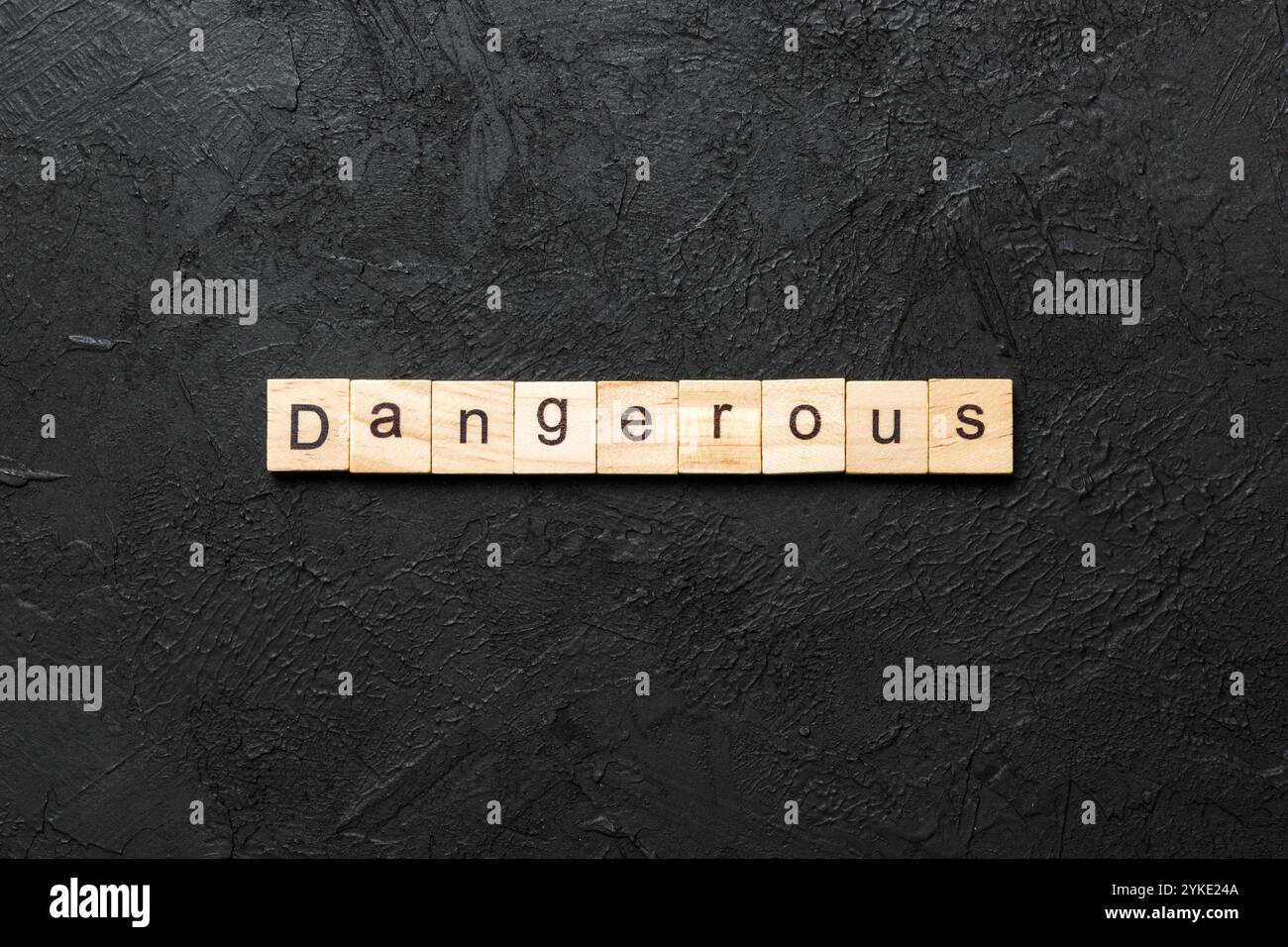 dangerous word written on wood block. dangerous text on cement table ...