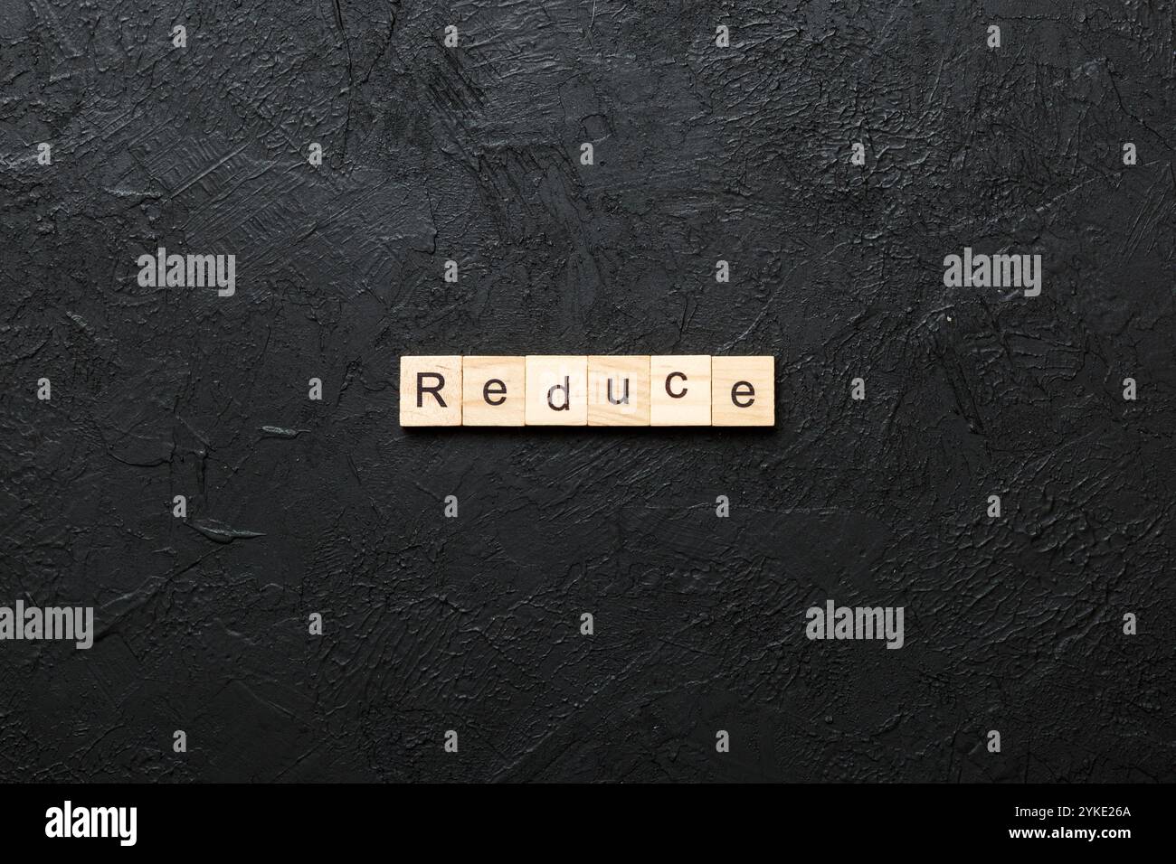 reduce word written on wood block. reduce text on cement table for your ...