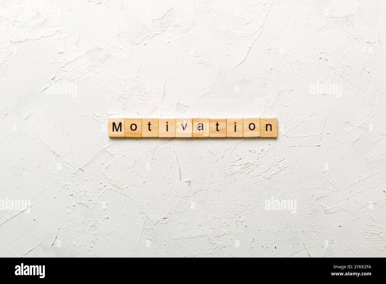 Motivation word written on wood block. Motivation text on cement table ...