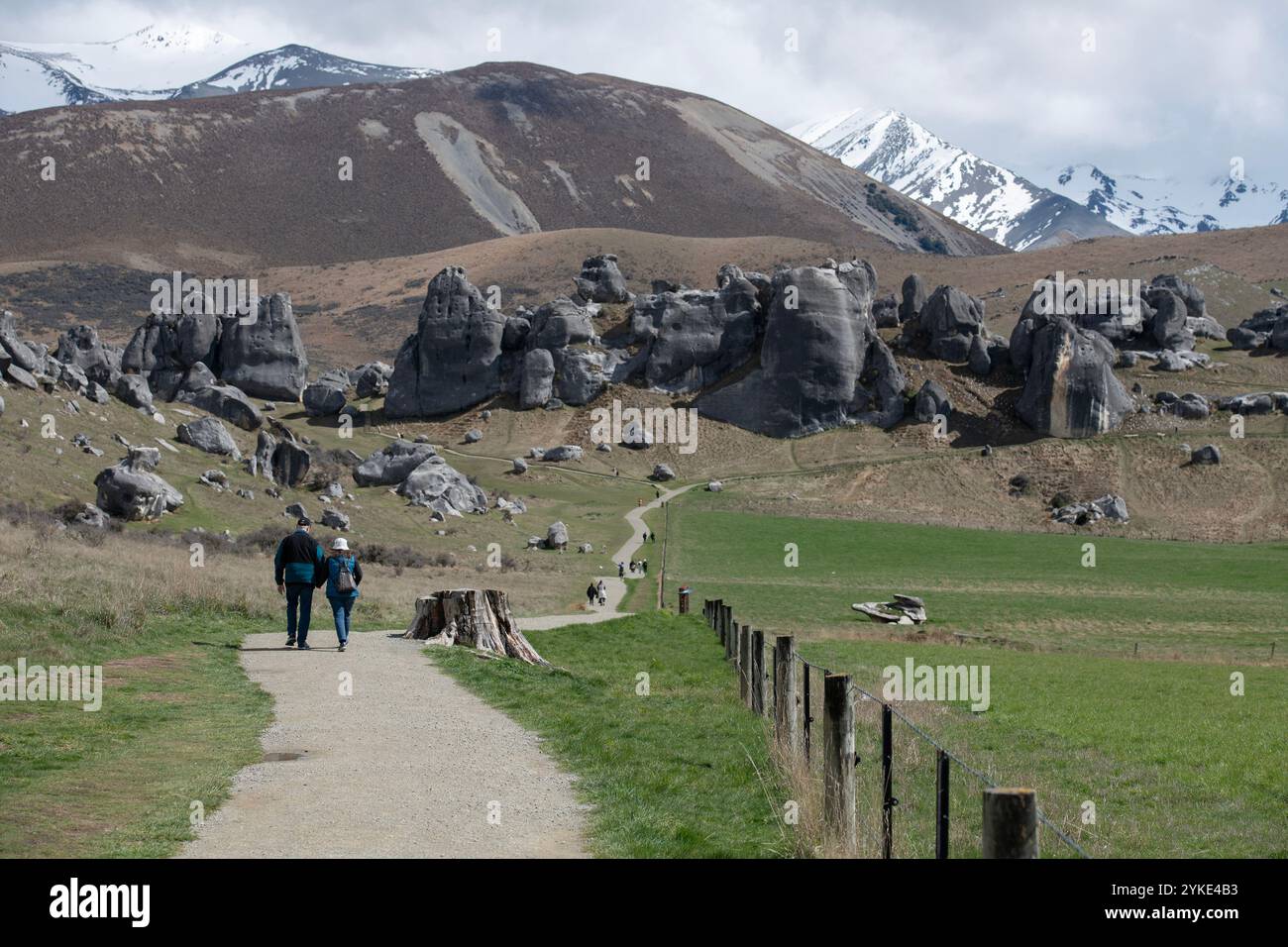 People on pathway walking towards limestone boulders with snow-covered ...