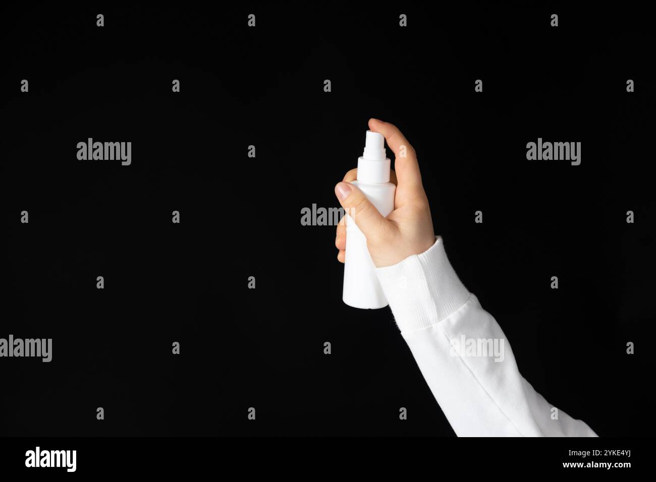 Hand with a spray can on a black background. Special product for ...