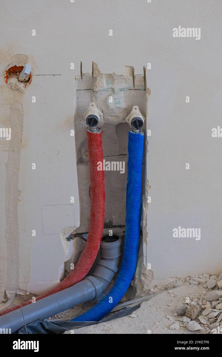 Installation of plumbing and sewer pipes in a prepared wall during home ...