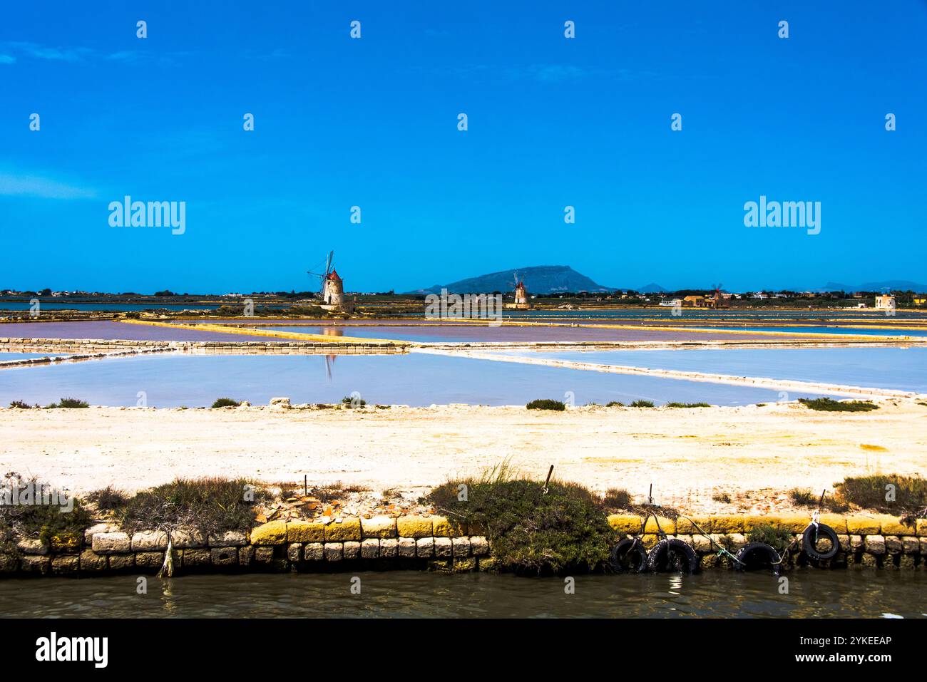 the Saline di Marsala in the Stagnone lagoon with old windmills and ...