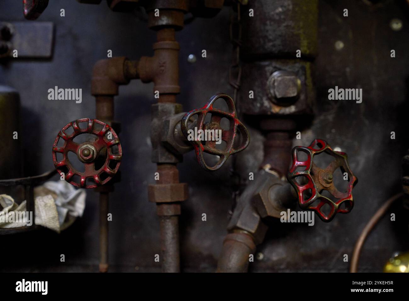 A collection of aged valves and pipes with a rusty finish, featuring ...