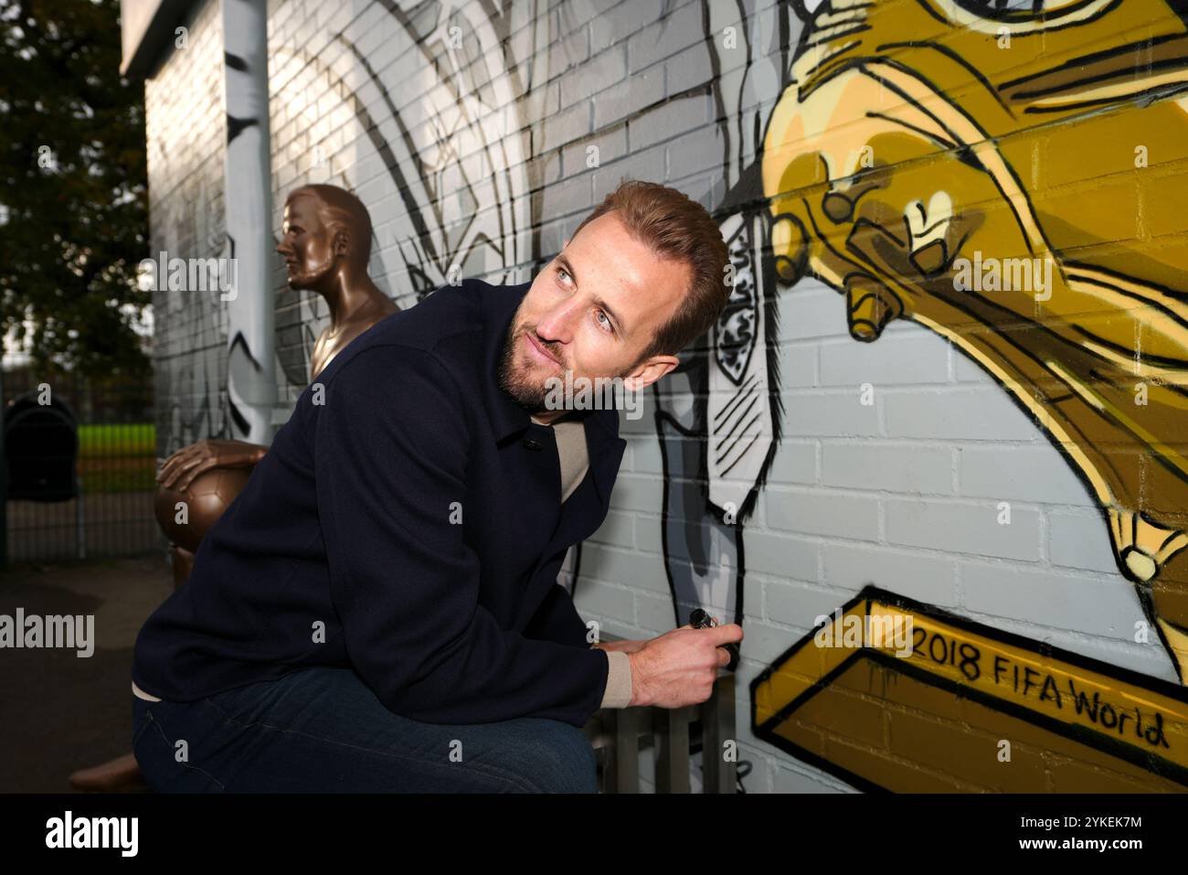 Harry Kane signs a mural during the unveiling of a statue of himself at ...