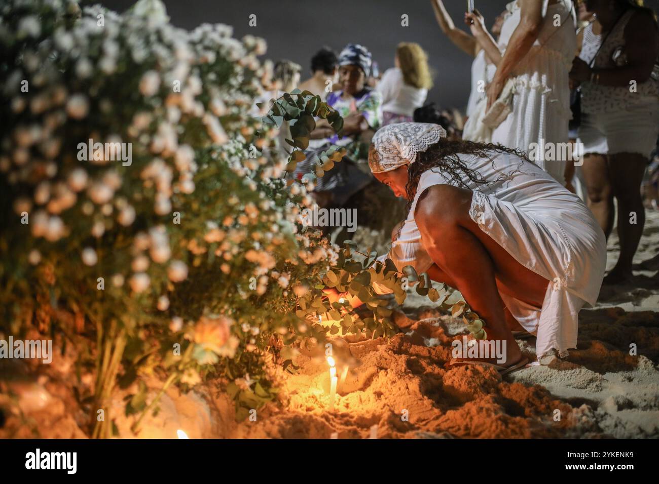 A believer lights a candle as an offering during the Festival of ...