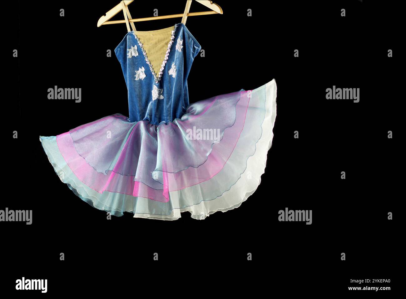 female ballet dancer costume hanging on wooden hanger, black background ...