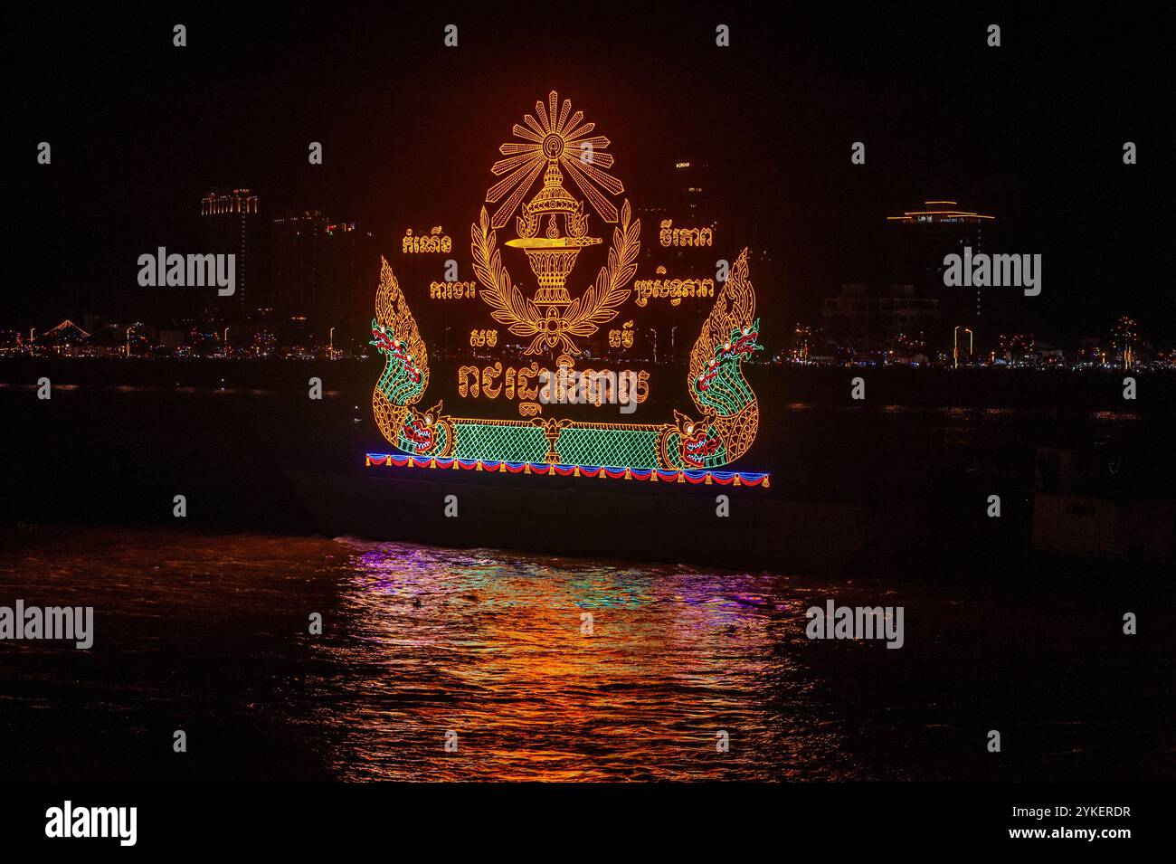 an Illuminated float / barge casts its reflection on the Tonle Sap ...