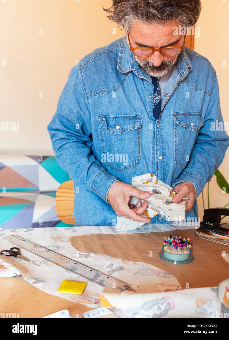 Adult man designing a piece of clothing at home for sewing Stock Photo ...