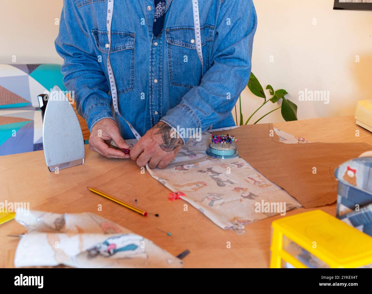 A man is sewing a piece of fabric with a needle and thread Stock Photo ...