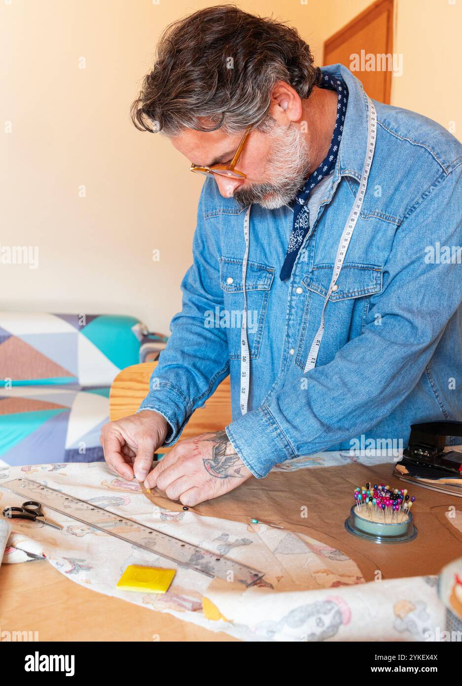 Adult man designing a piece of clothing at home for sewing Stock Photo ...