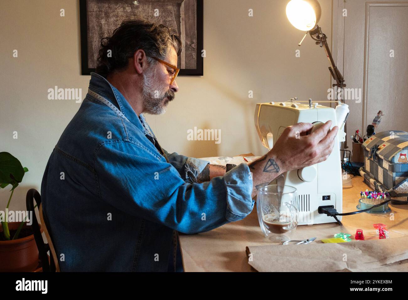 A man sewing at home with sewing machines Stock Photo - Alamy