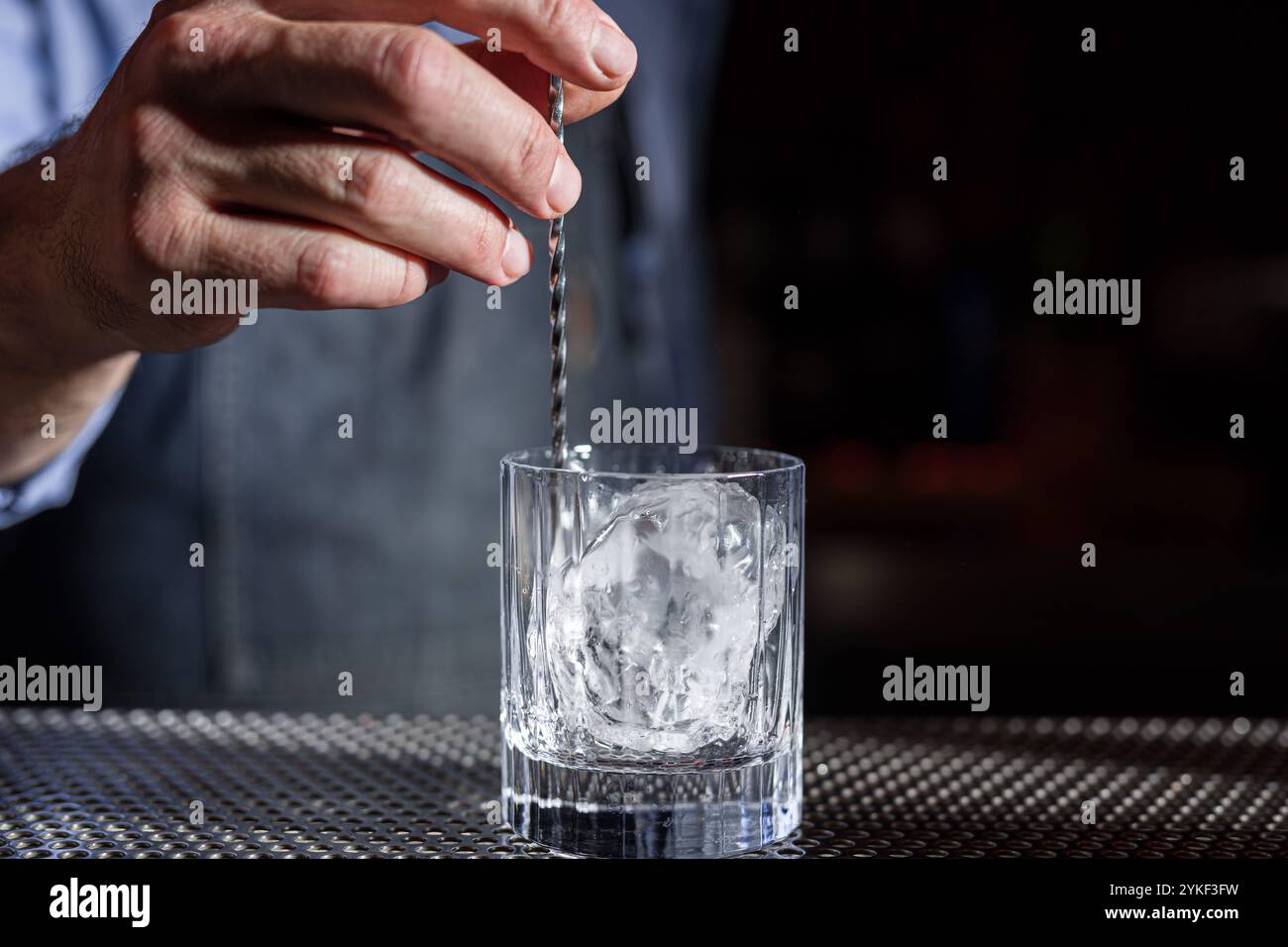 A bartender begins by preparing a classic old-fashioned whiskey with a ...