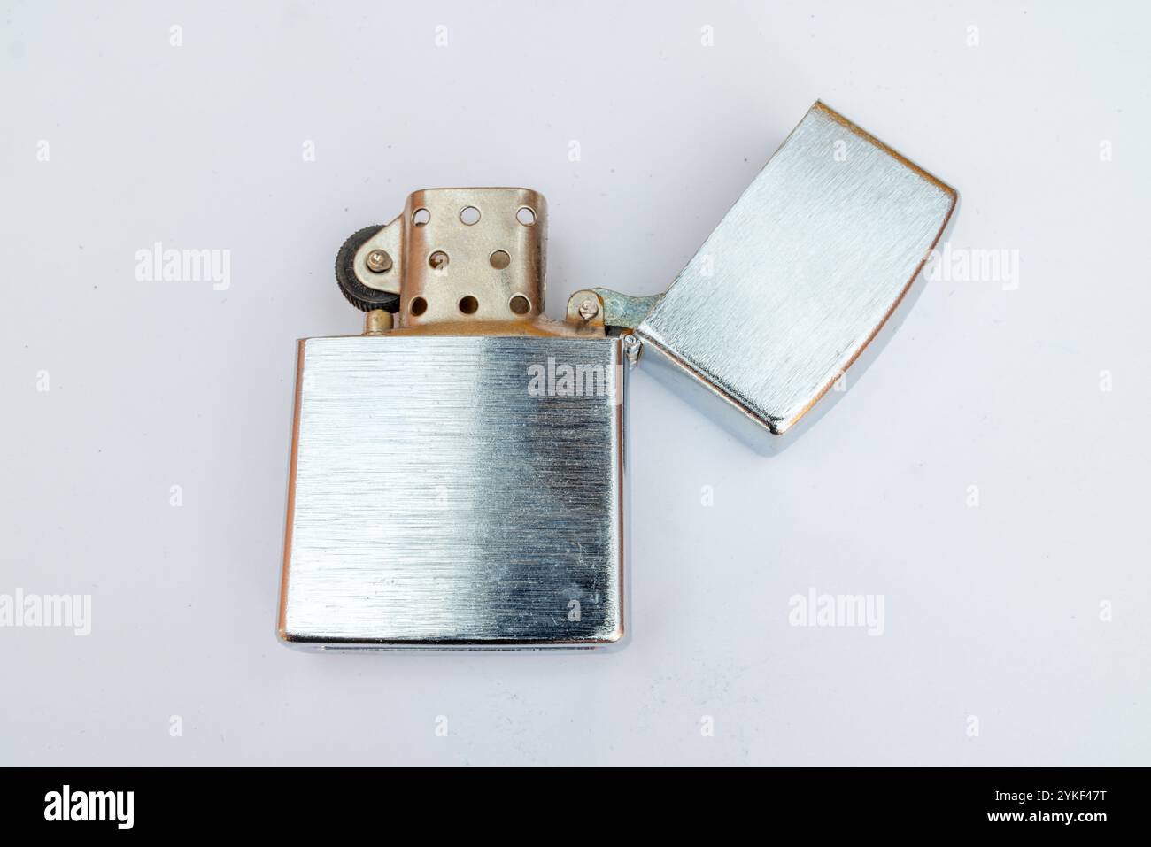 An old 1980's style siver oil filled flick lighter showing the open lid ...