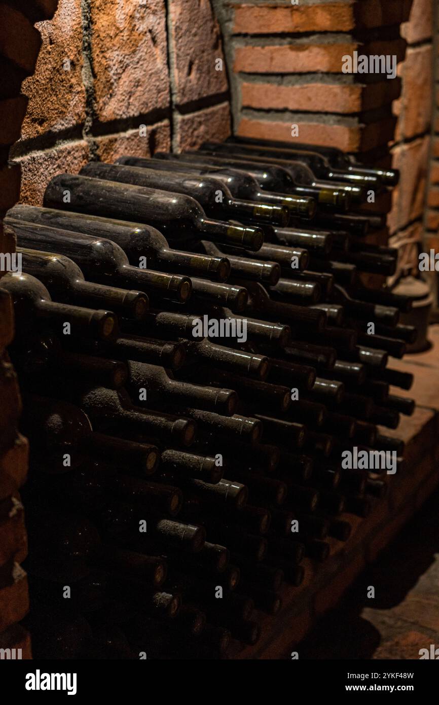 A mysterious view of numerous dusty wine bottles stacked in an old ...