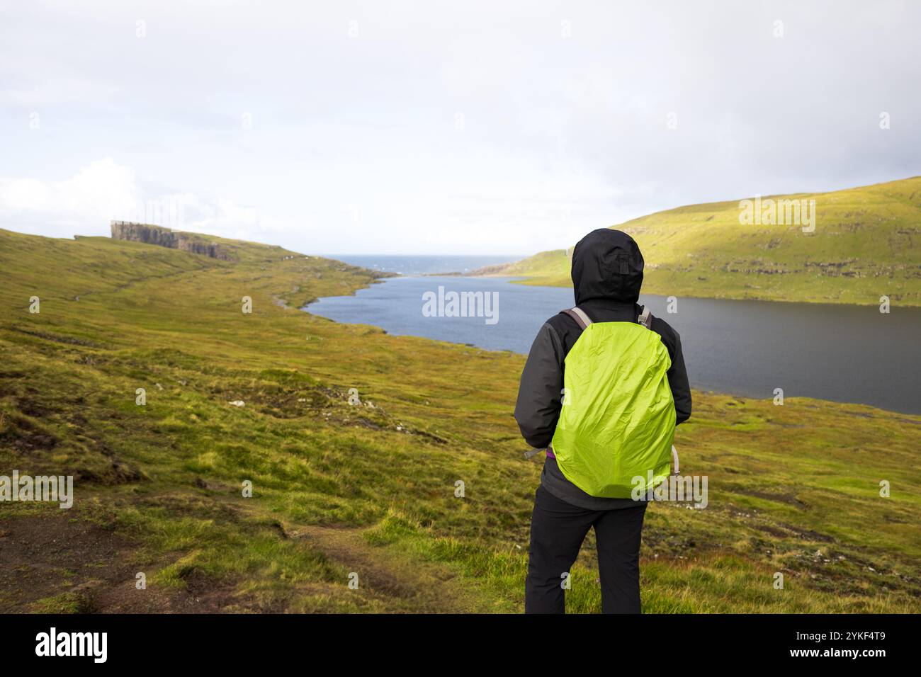 Man hikining Leitisvatn, the floating lake above the ocean, Traelanipa ...