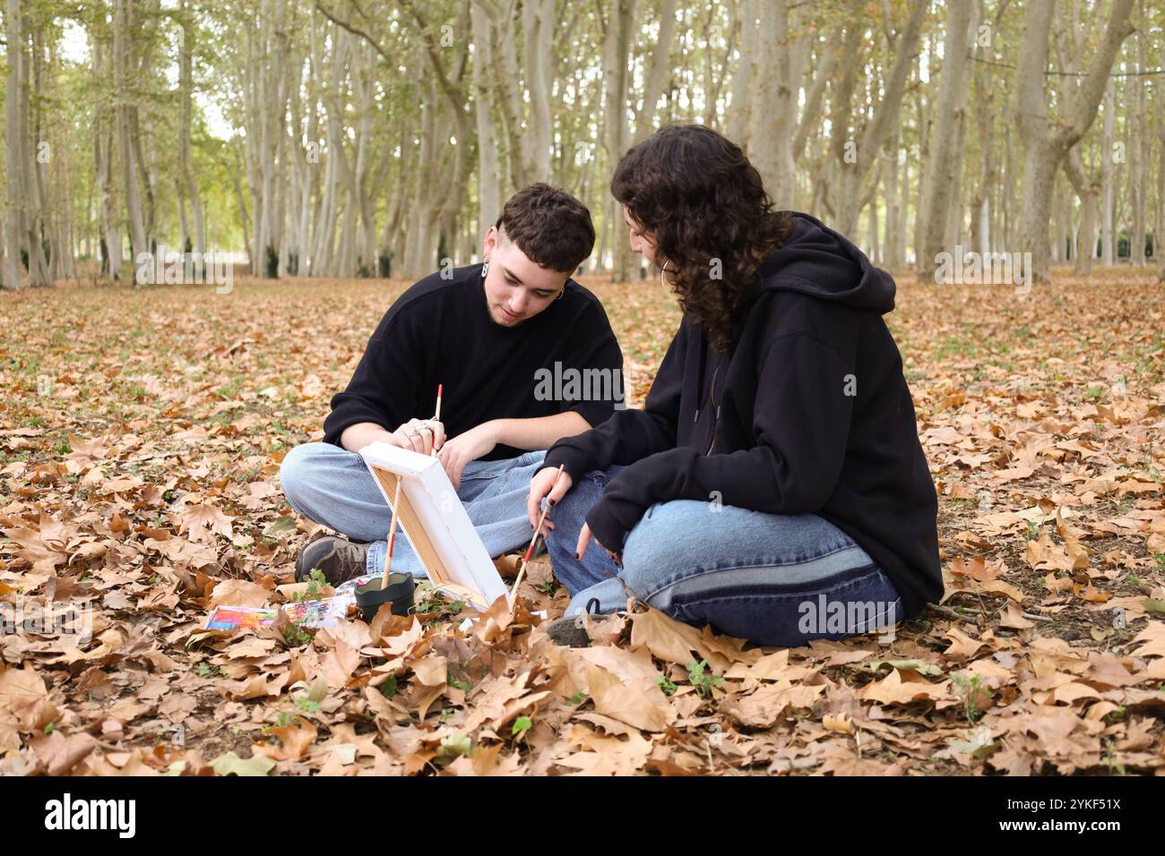 In a quiet park full of autumn leaves, an LGBTQIA+ couple shares a ...