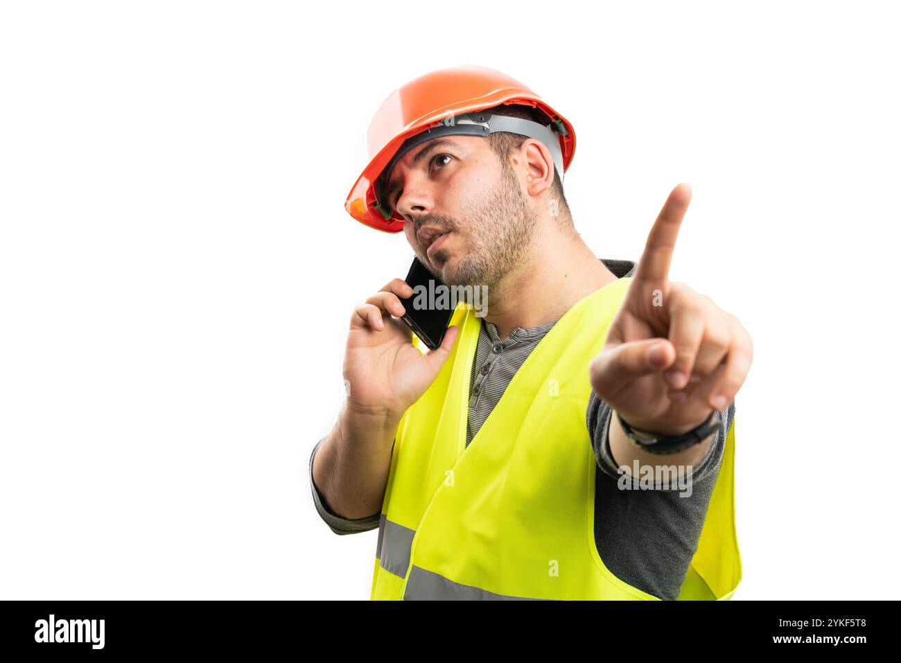 Male trades construction worker talking on phone with serious ...