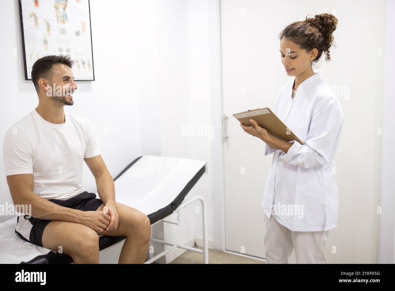 A doctor consults with a smiling patient in an orthopedics office The ...