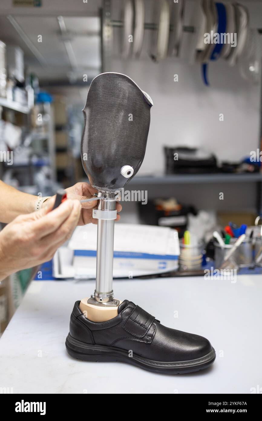 A close-up shot of a technician's hands adjusting a prosthetic leg The ...