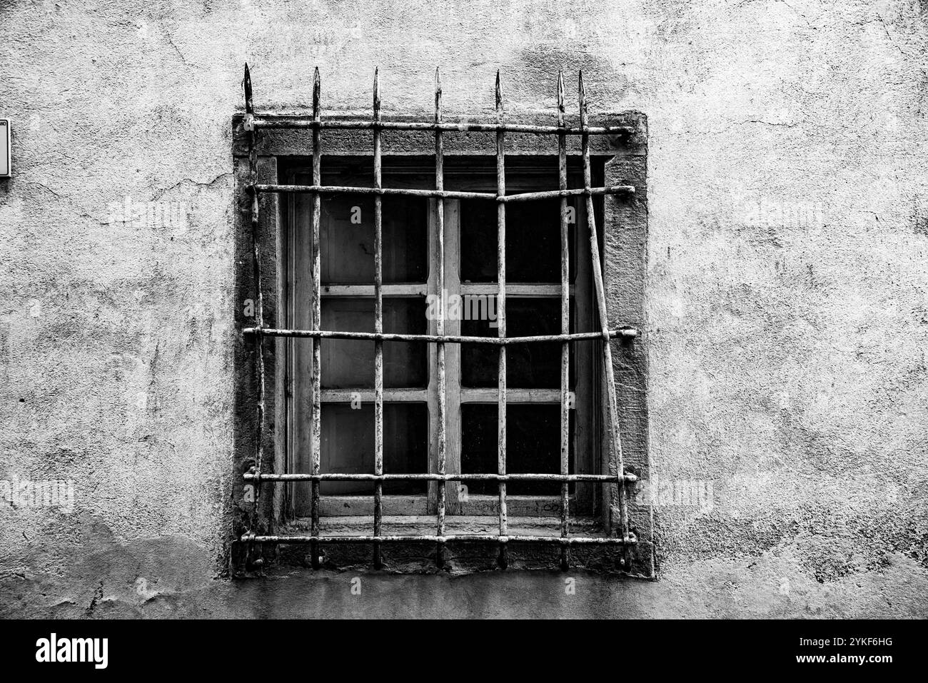 photograph of an old grunge black and white window with rusty grille ...