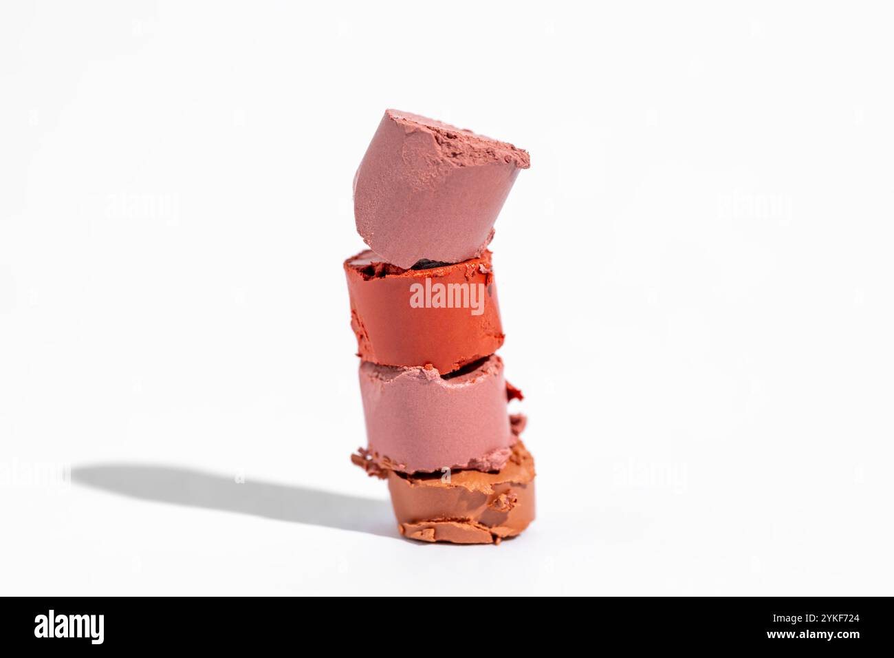 A vertical stack of lipstick pieces in various shades, showcasing their ...