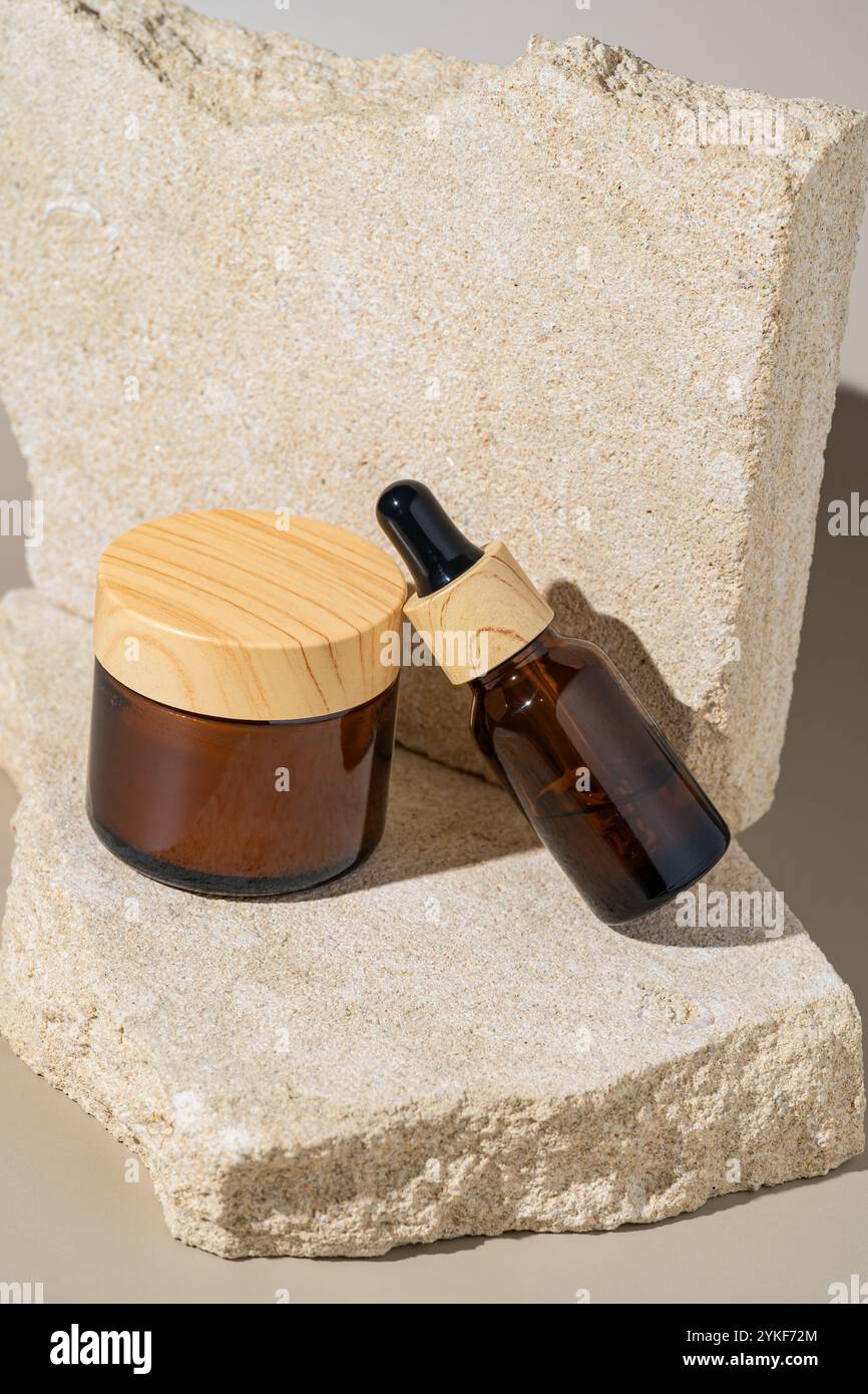 Minimalist eco-friendly cosmetic containers placed on textured stone ...