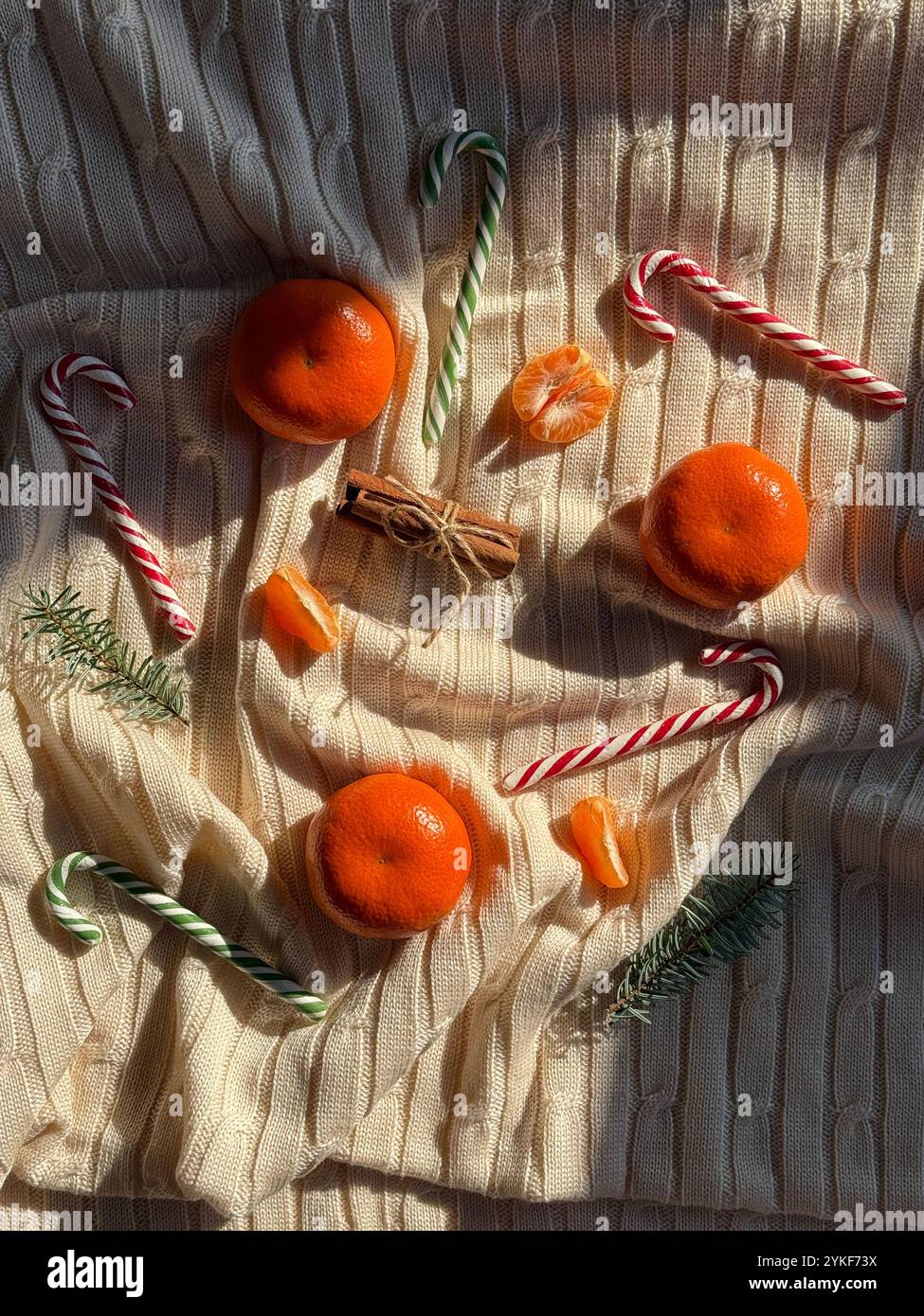 Top view of a textured fabric background adorned with mandarins, candy ...
