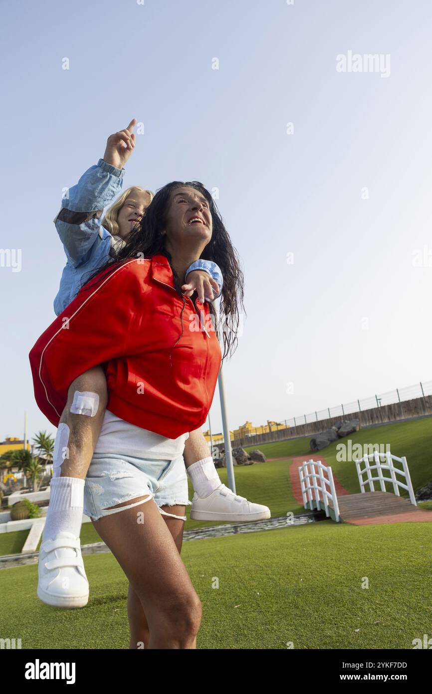 A girl with Stuve-Wiedemann syndrome, wearing medical patches, rides on ...