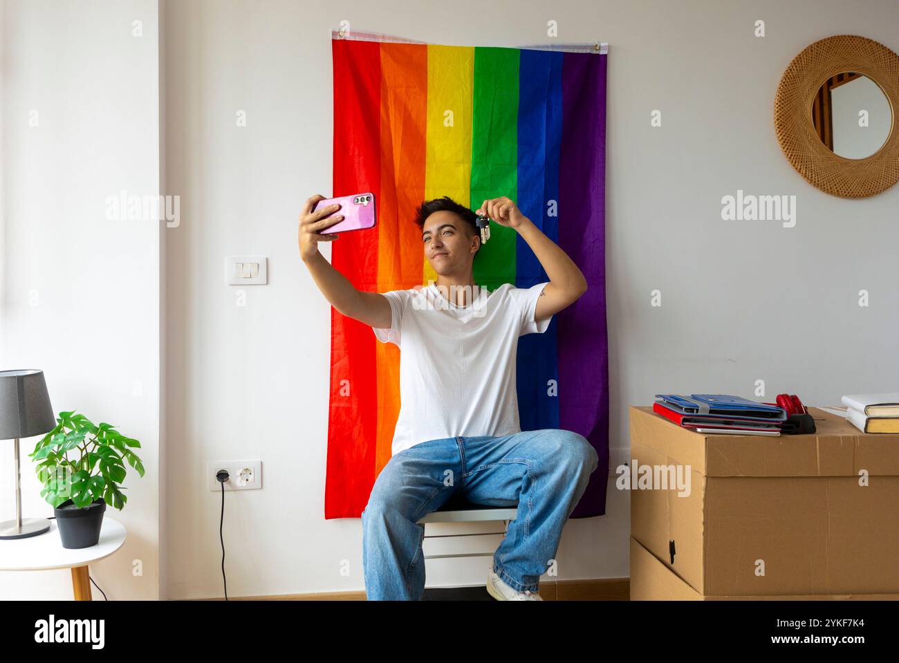 A trans man takes a joyful selfie with a pride flag, celebrating his ...